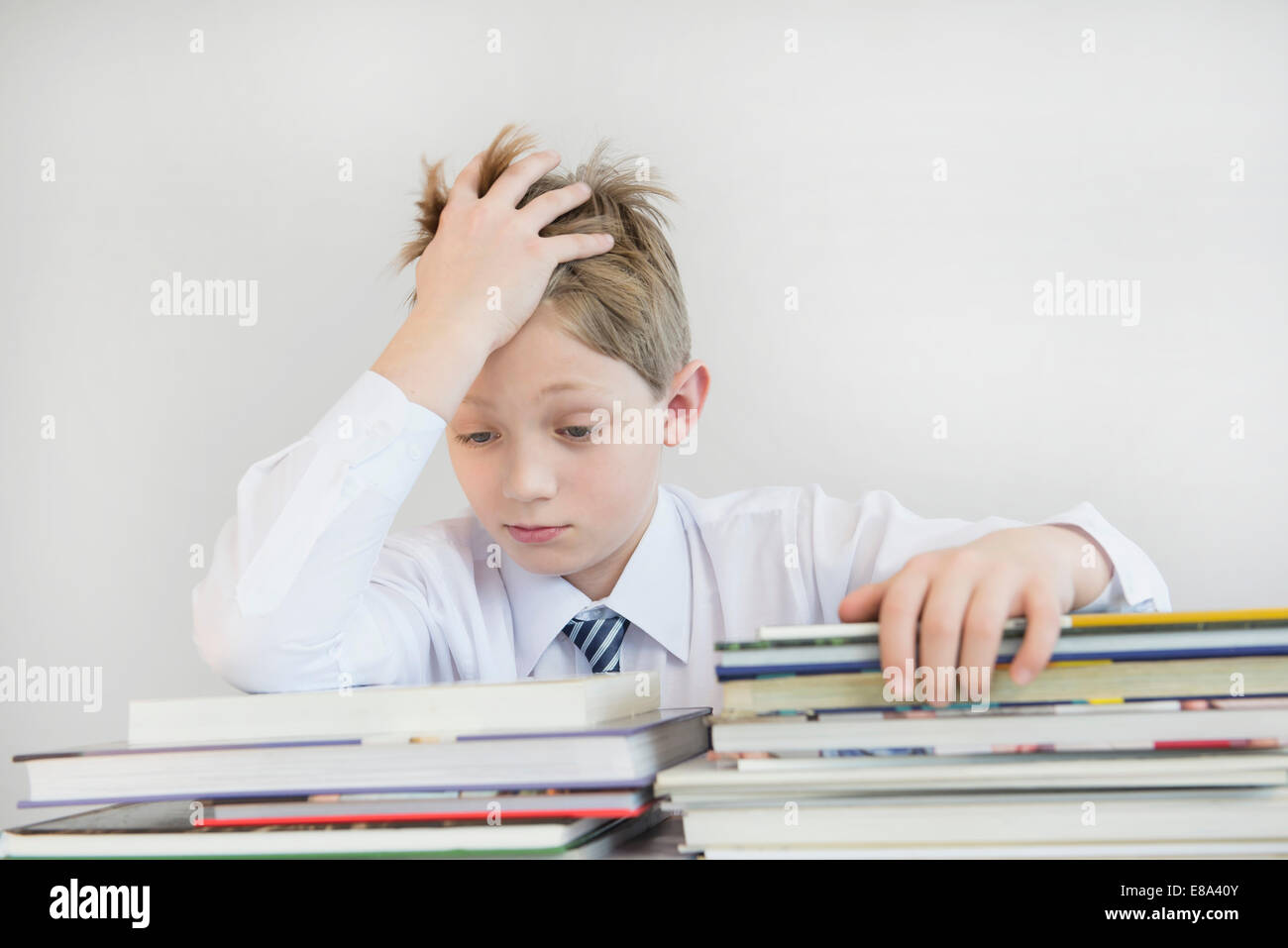 Frustrated boy with stack of books, close up Stock Photo - Alamy