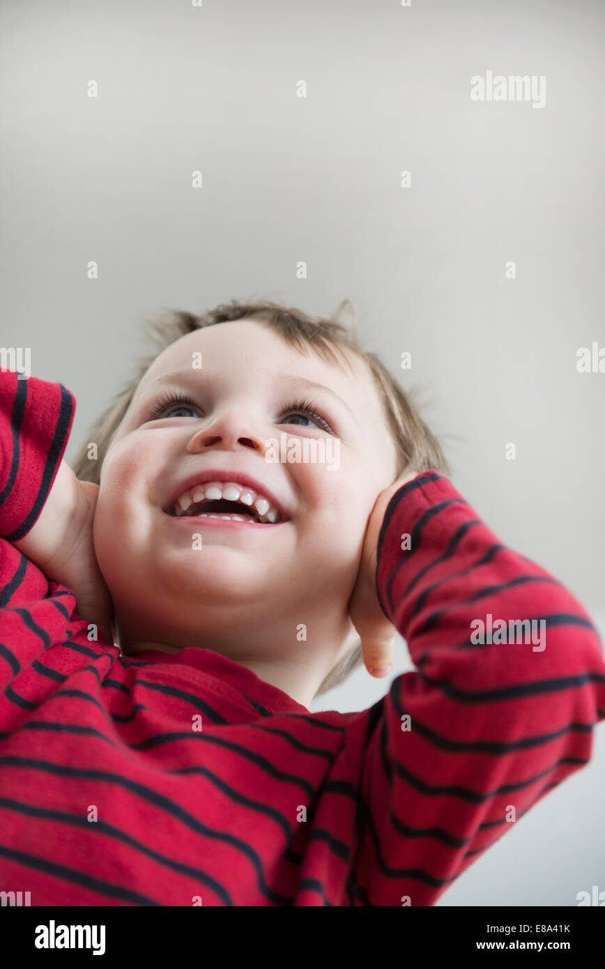 Boy covering ears, smiling Stock Photo - Alamy
