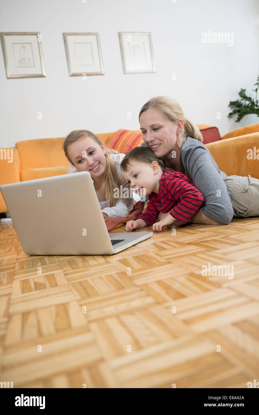 Family using laptop in living room, smiling Stock Photo - Alamy