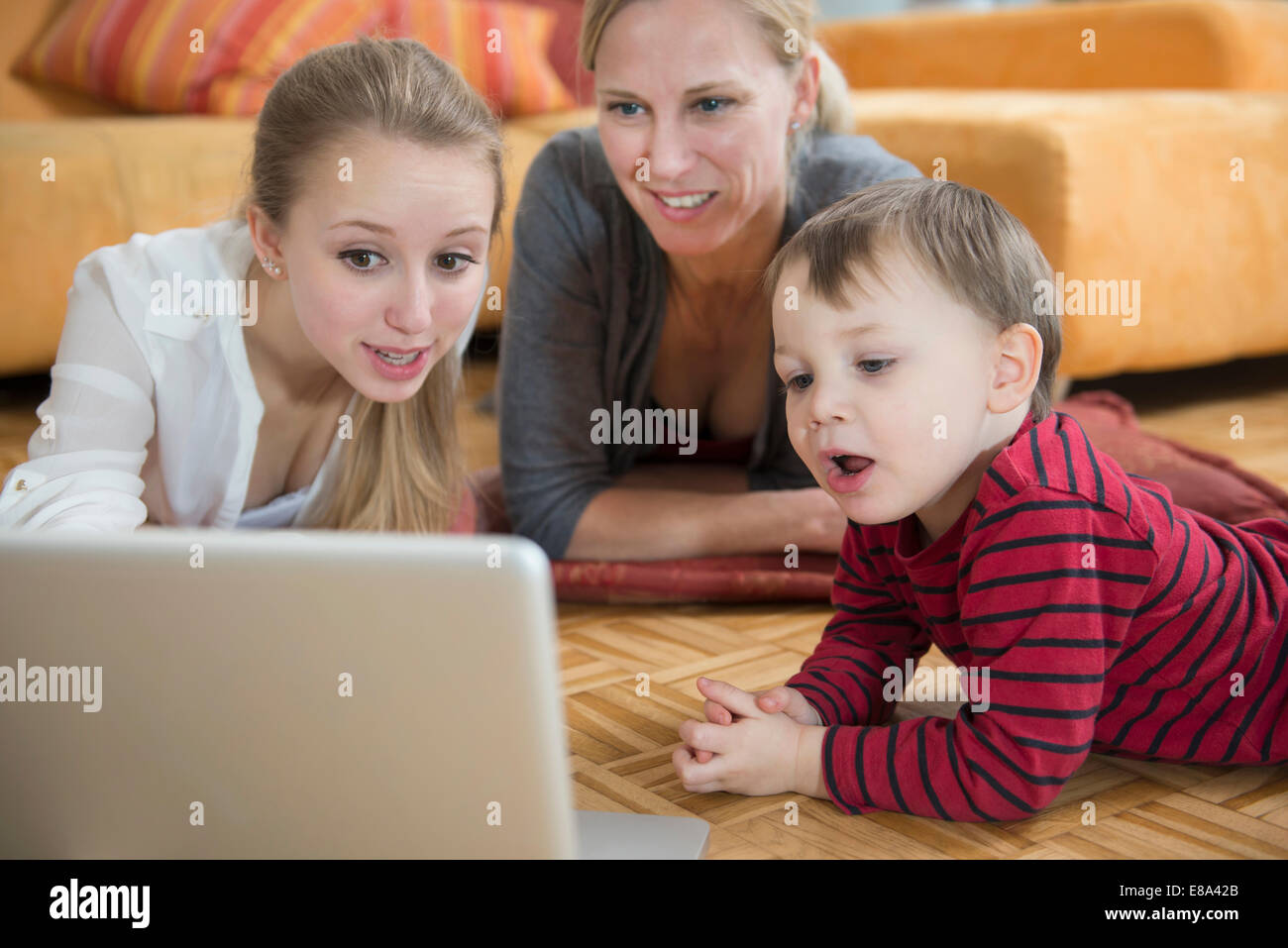 Family using laptop in living room, smiling Stock Photo - Alamy