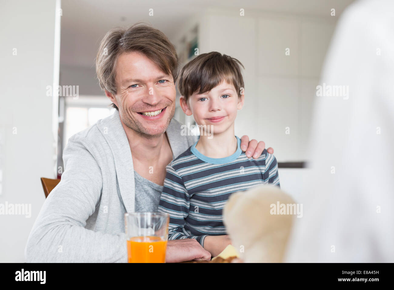 Portrait of father and son at breakfast table, smiling Stock Photo - Alamy