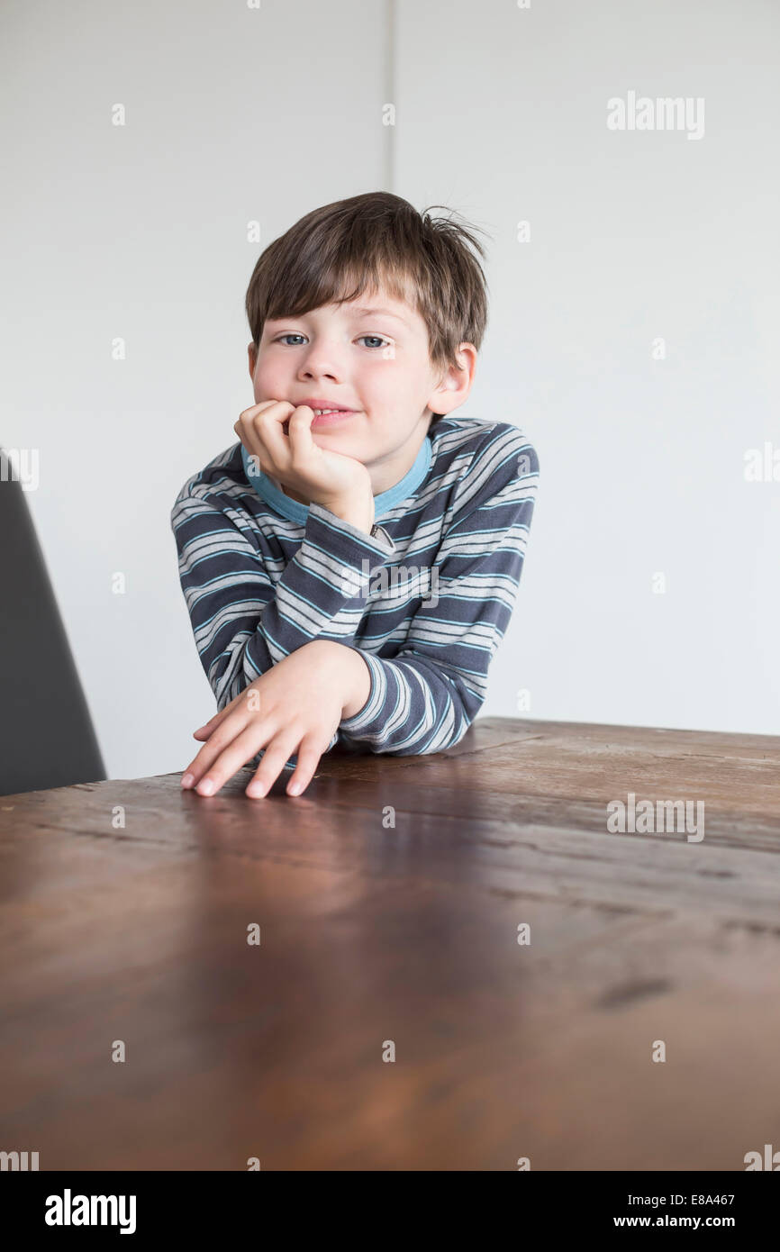 Portrait of boy leaning on table, close up Stock Photo - Alamy