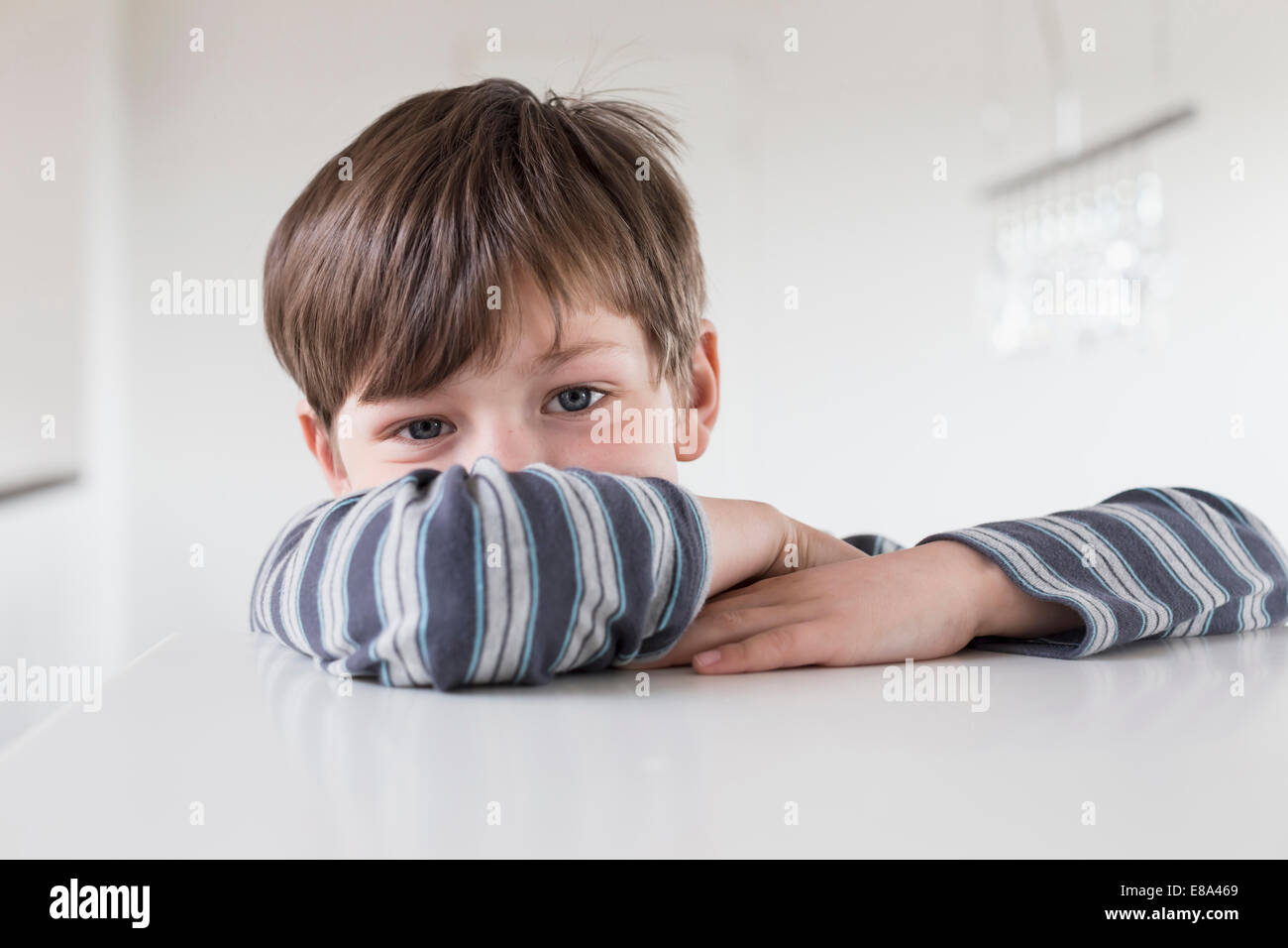 Portrait of boy leaning on table, close up Stock Photo - Alamy