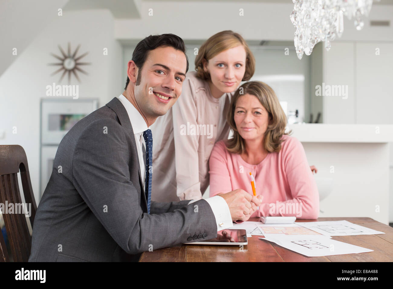 Smiling consultant and mature and young woman at home Stock Photo - Alamy