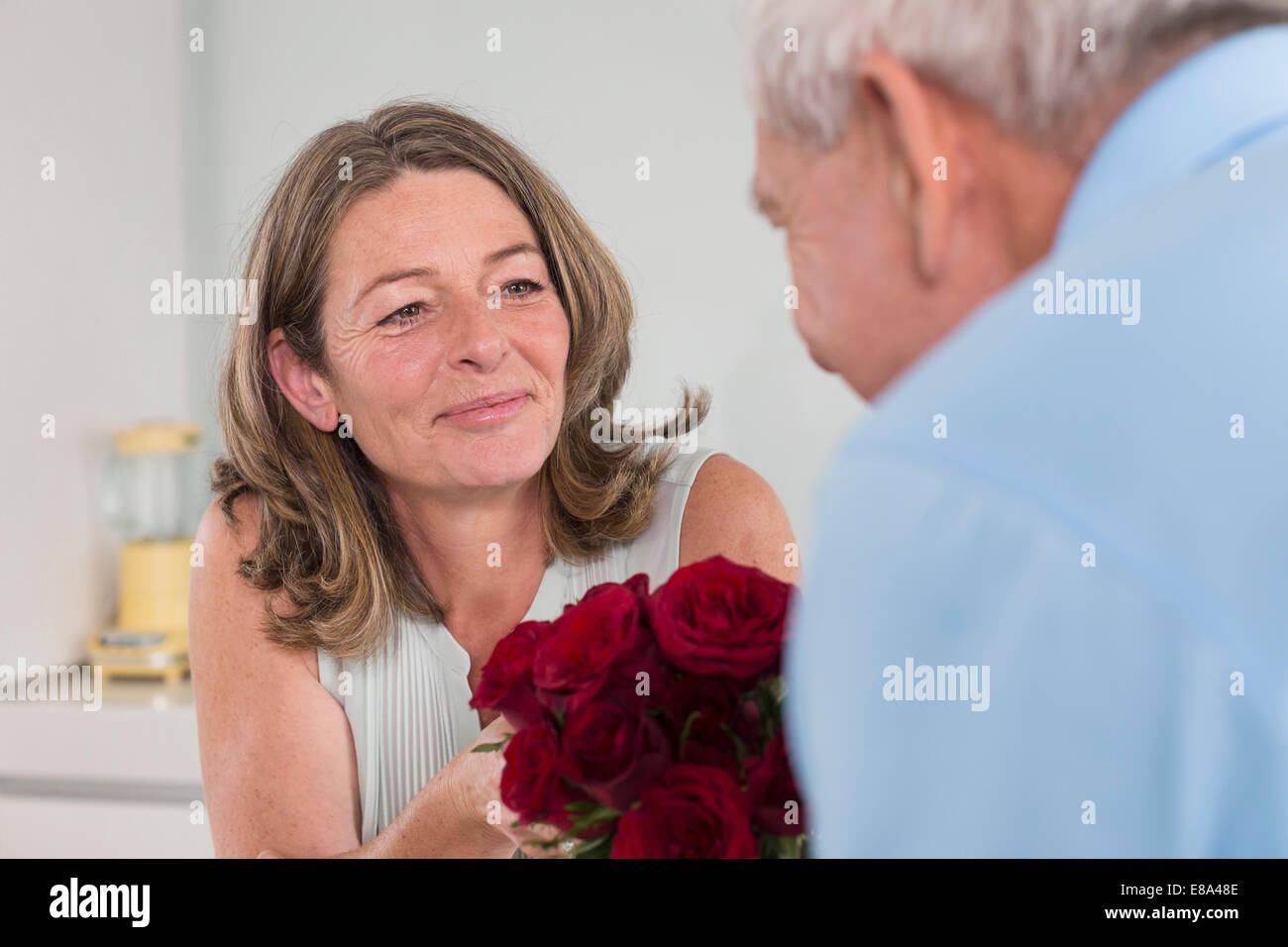 Senior man giving red roses to woman Stock Photo - Alamy