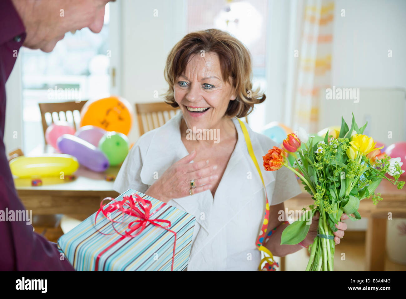 Senior man hand over present to woman on birthday, smiling Stock Photo ...
