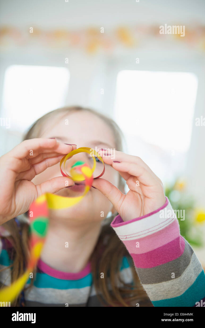 Portrait of girl with blowout paper streamer at birthday party, smiling ...