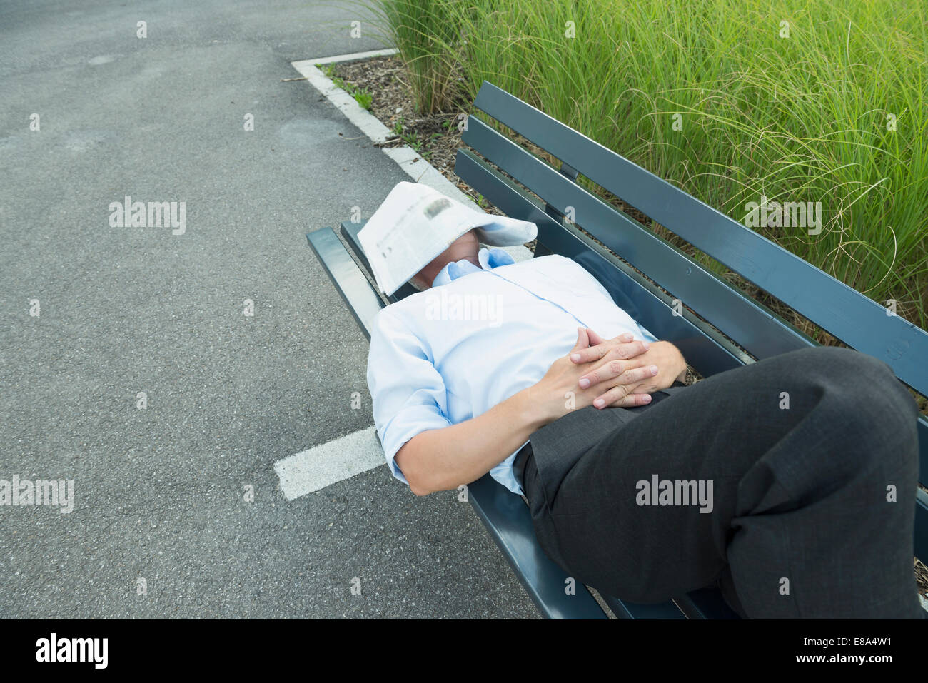 man covered with newspaper is sleeping on a bench Stock Photo - Alamy