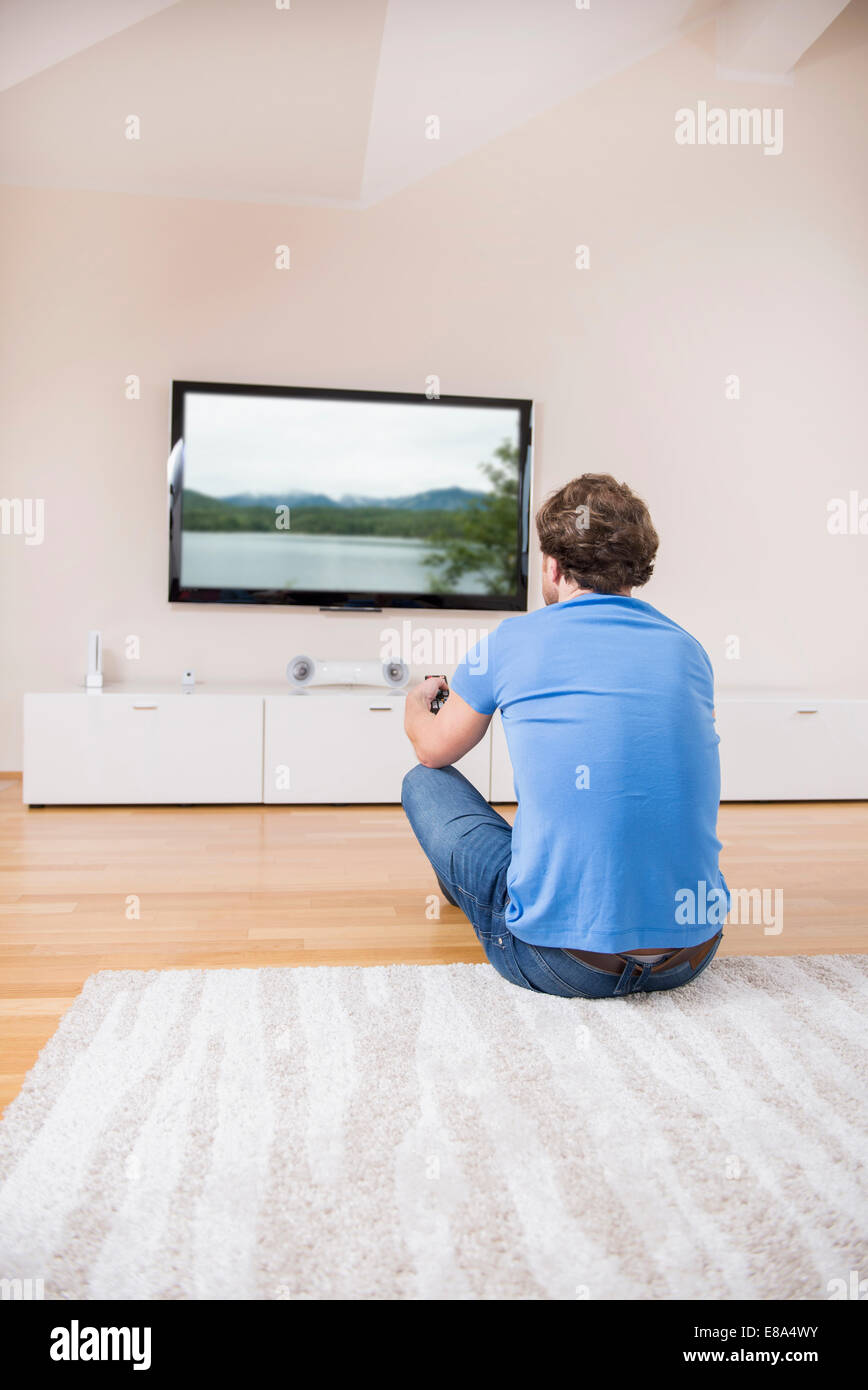 Man watching TV at home Stock Photo - Alamy