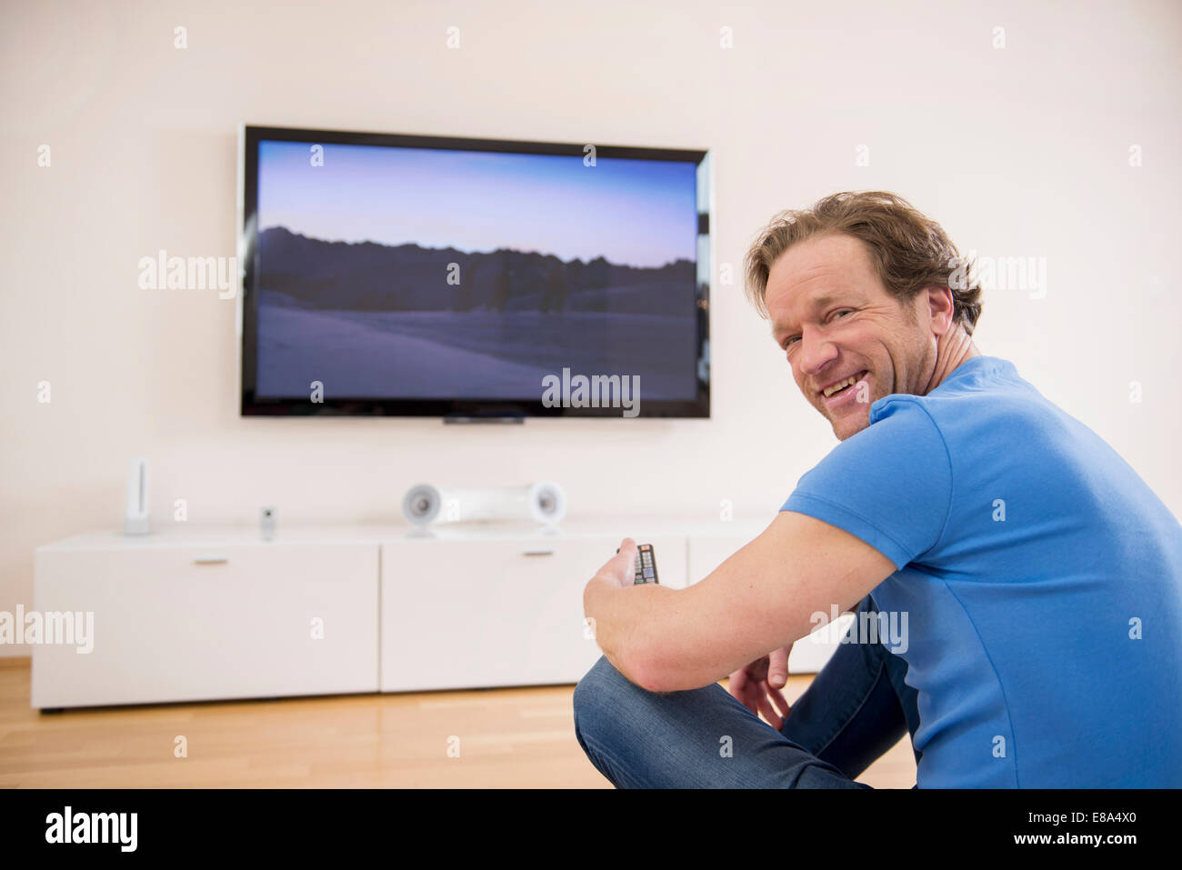 Man watching TV at home Stock Photo - Alamy