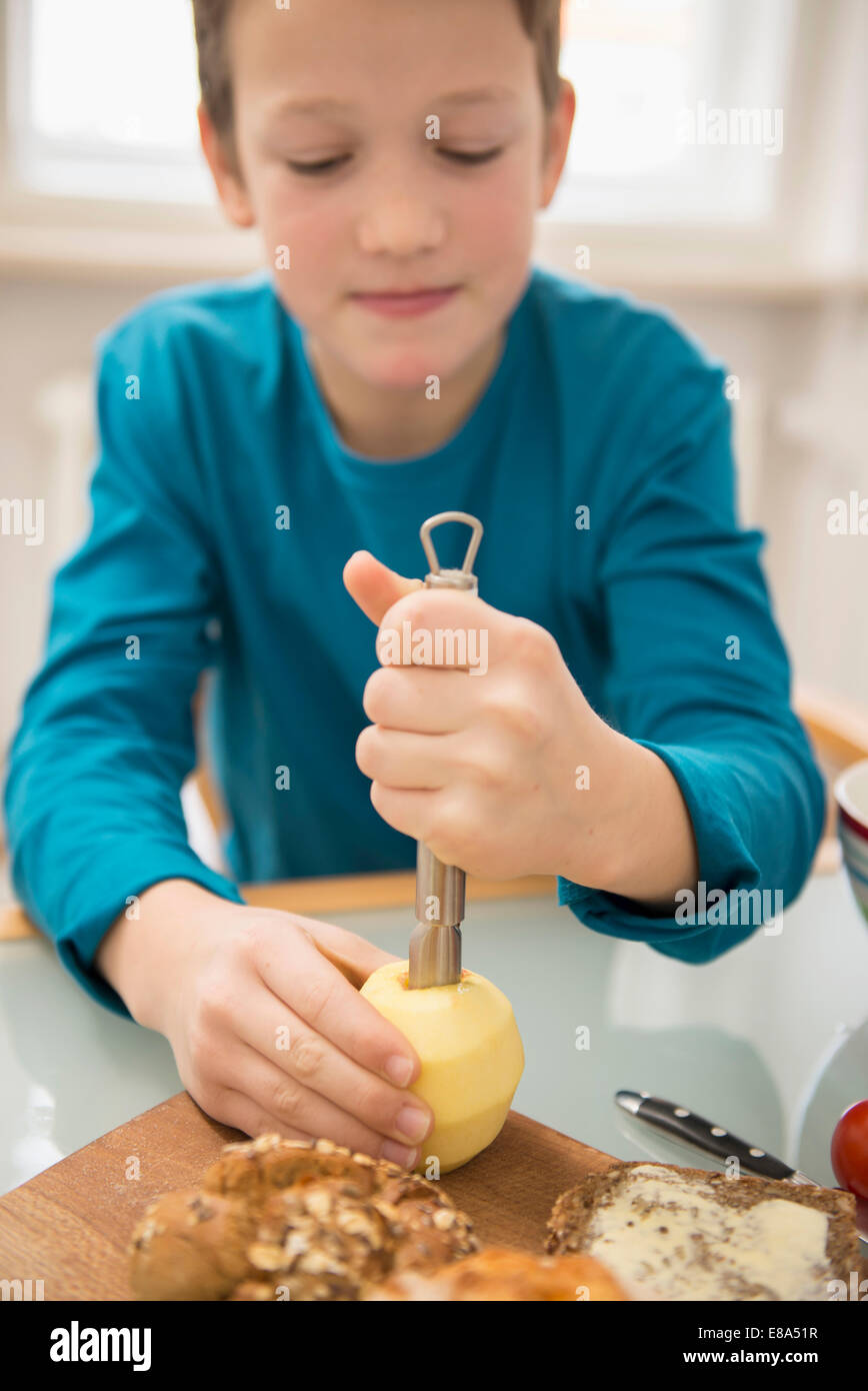 Boy coring apple in kitchen Stock Photo - Alamy
