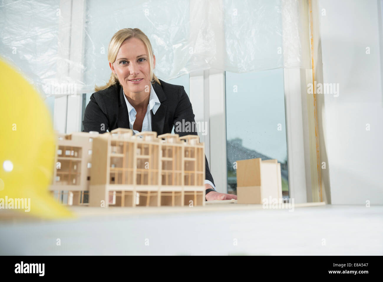 Female architect with architectural model at construction site Stock ...