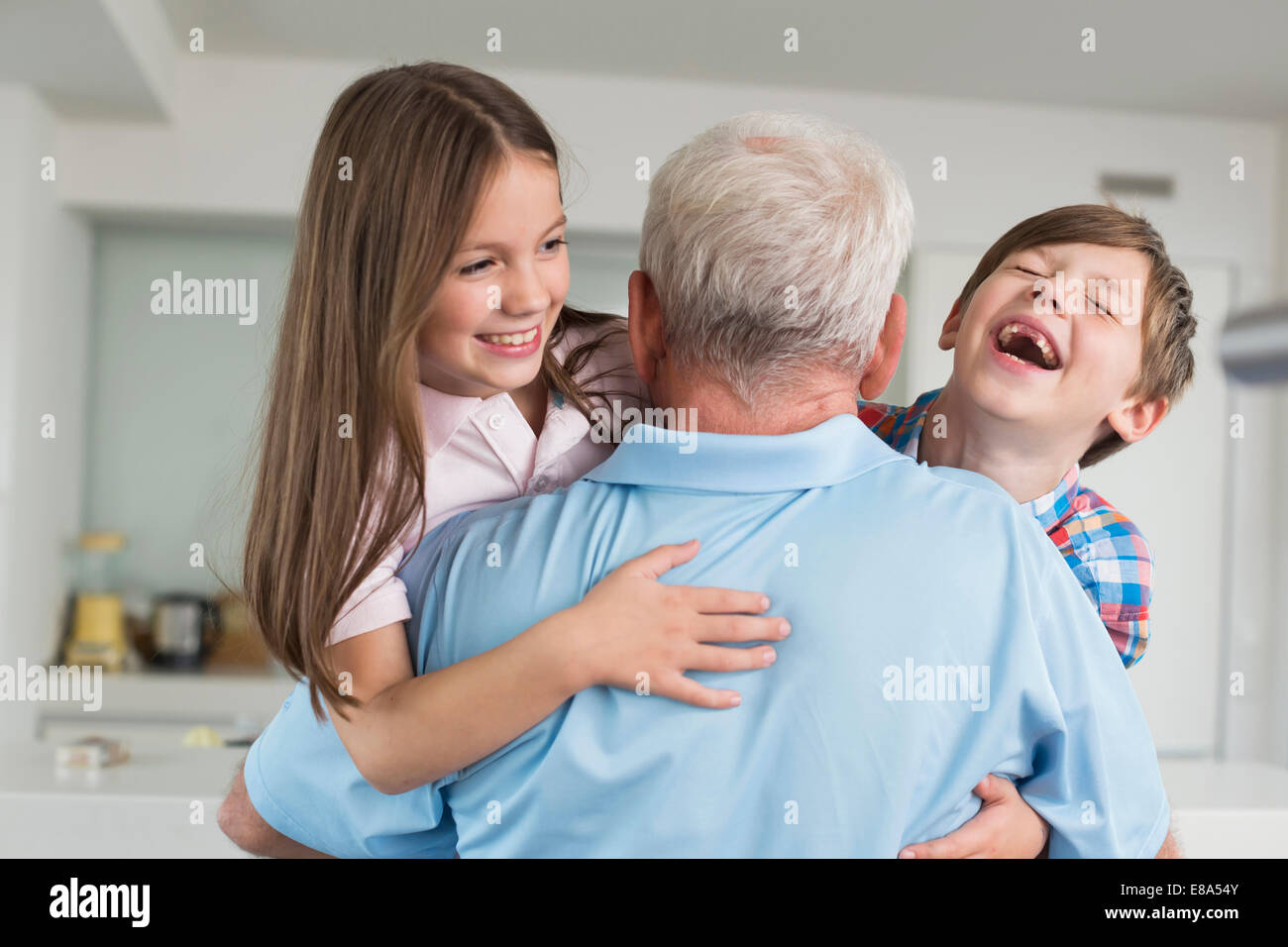 Grandfather hugging happy grandchildren Stock Photo - Alamy