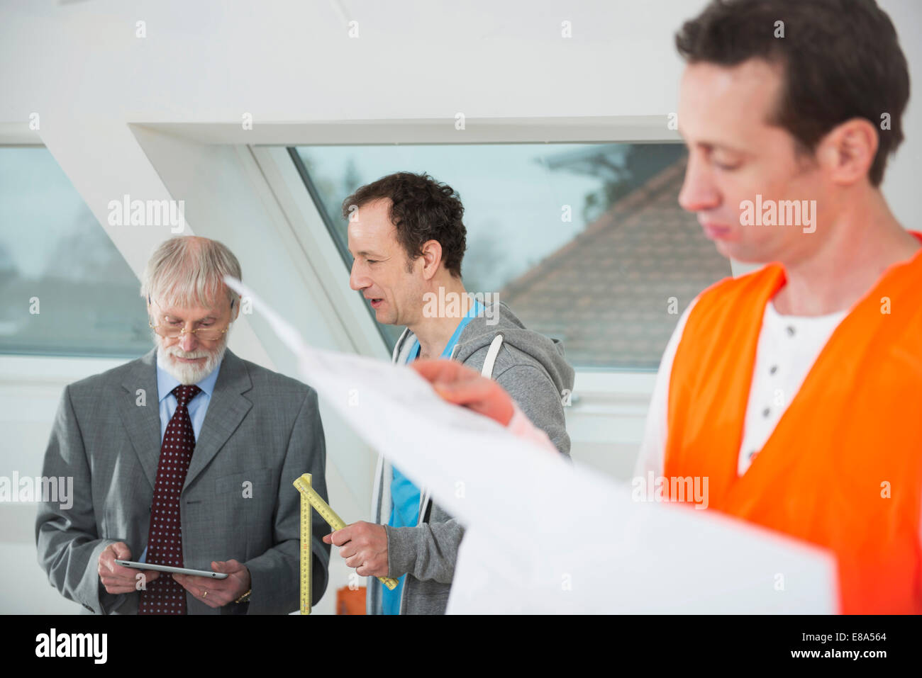 Architect, building owner and construction worker at construction site ...