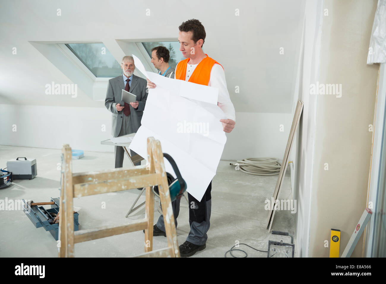 Architect, building owner and construction worker at construction site ...