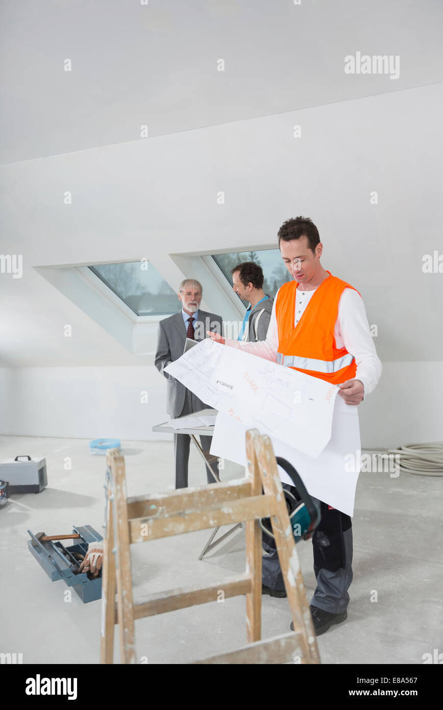 Architect, building owner and construction worker at construction site ...