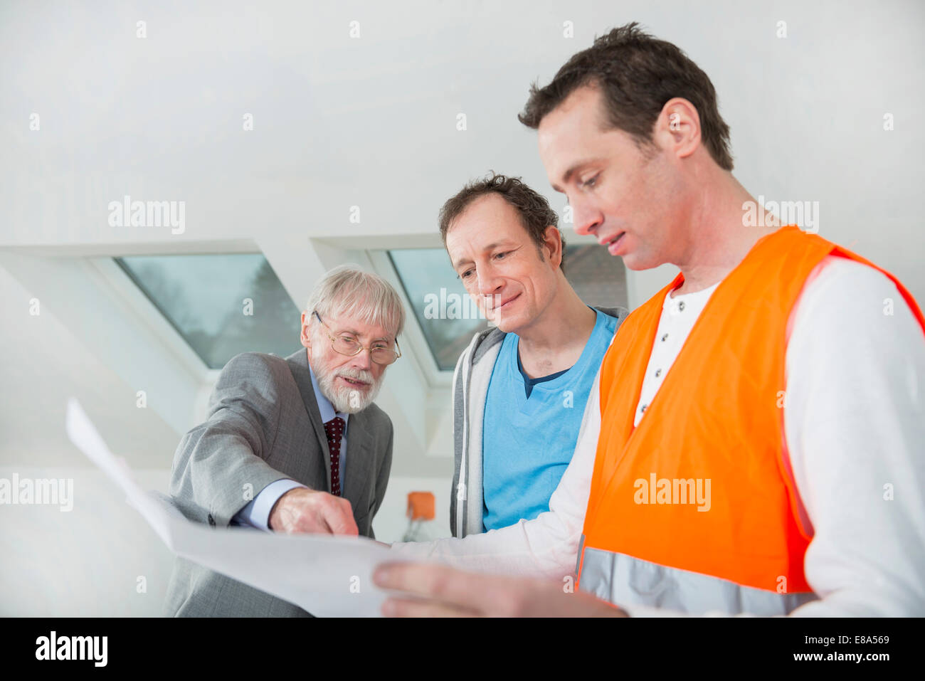 Architect, building owner and construction worker at construction site ...