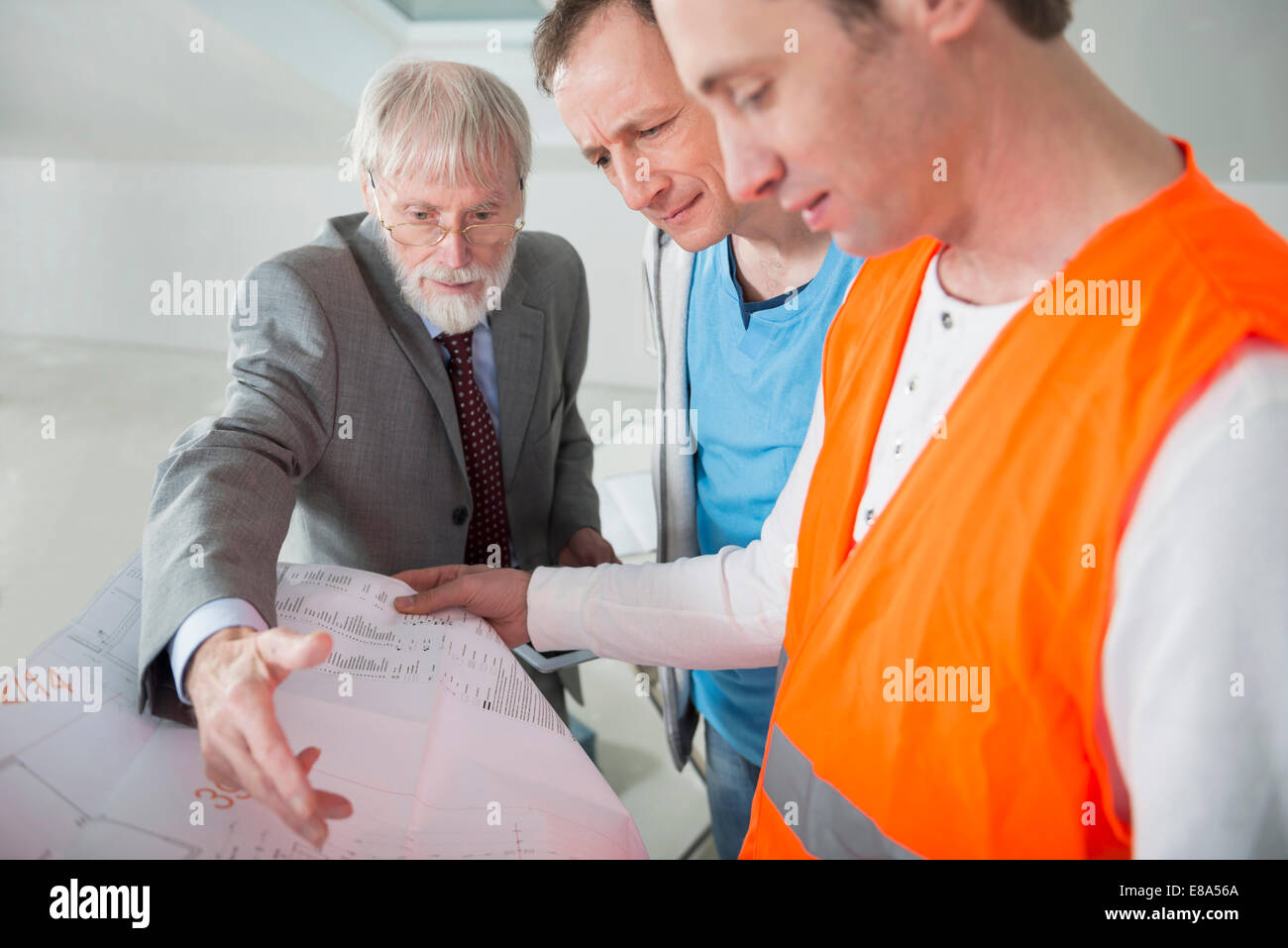 Architect, building owner and construction worker at construction site ...