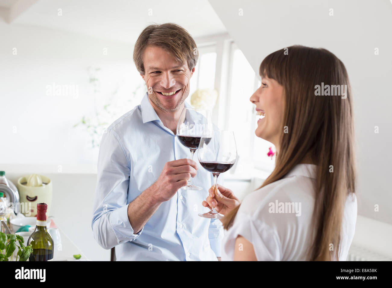 Couple having glass of wine together, smiling Stock Photo - Alamy