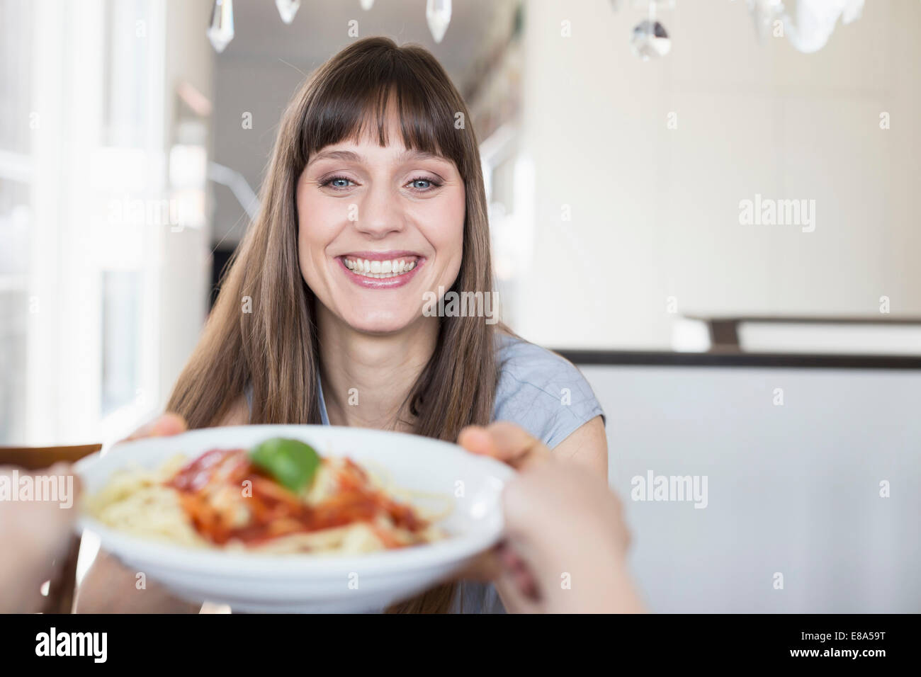 Portrait of woman with spaghetti plate, smiling Stock Photo - Alamy