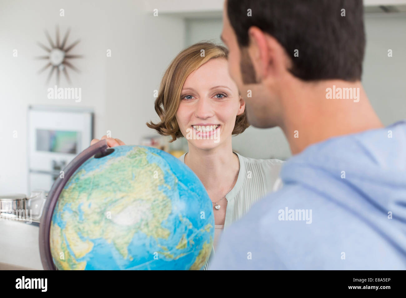 Smiling couple with globe Stock Photo - Alamy