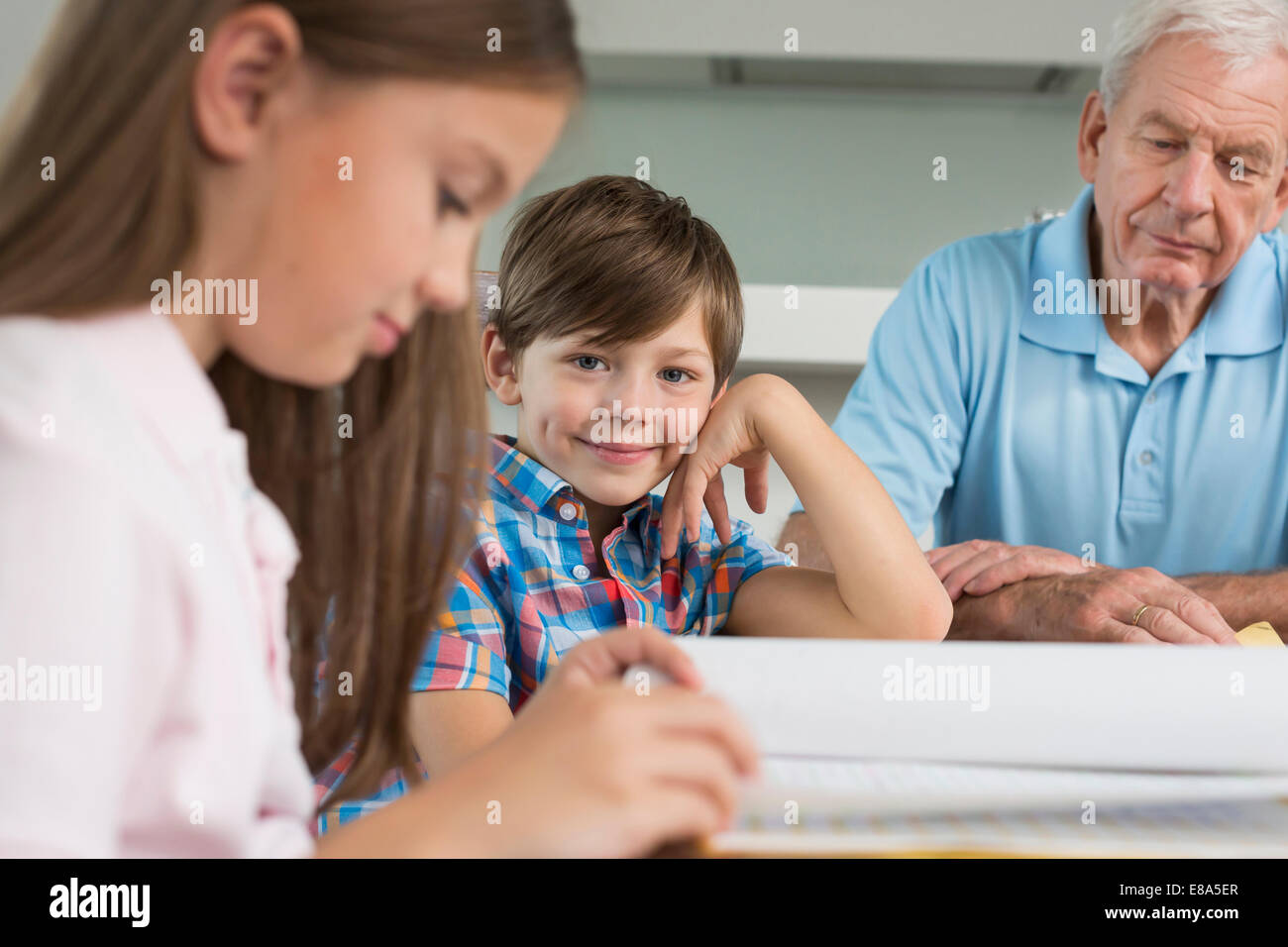 Children doing homework with their grandfather Stock Photo - Alamy