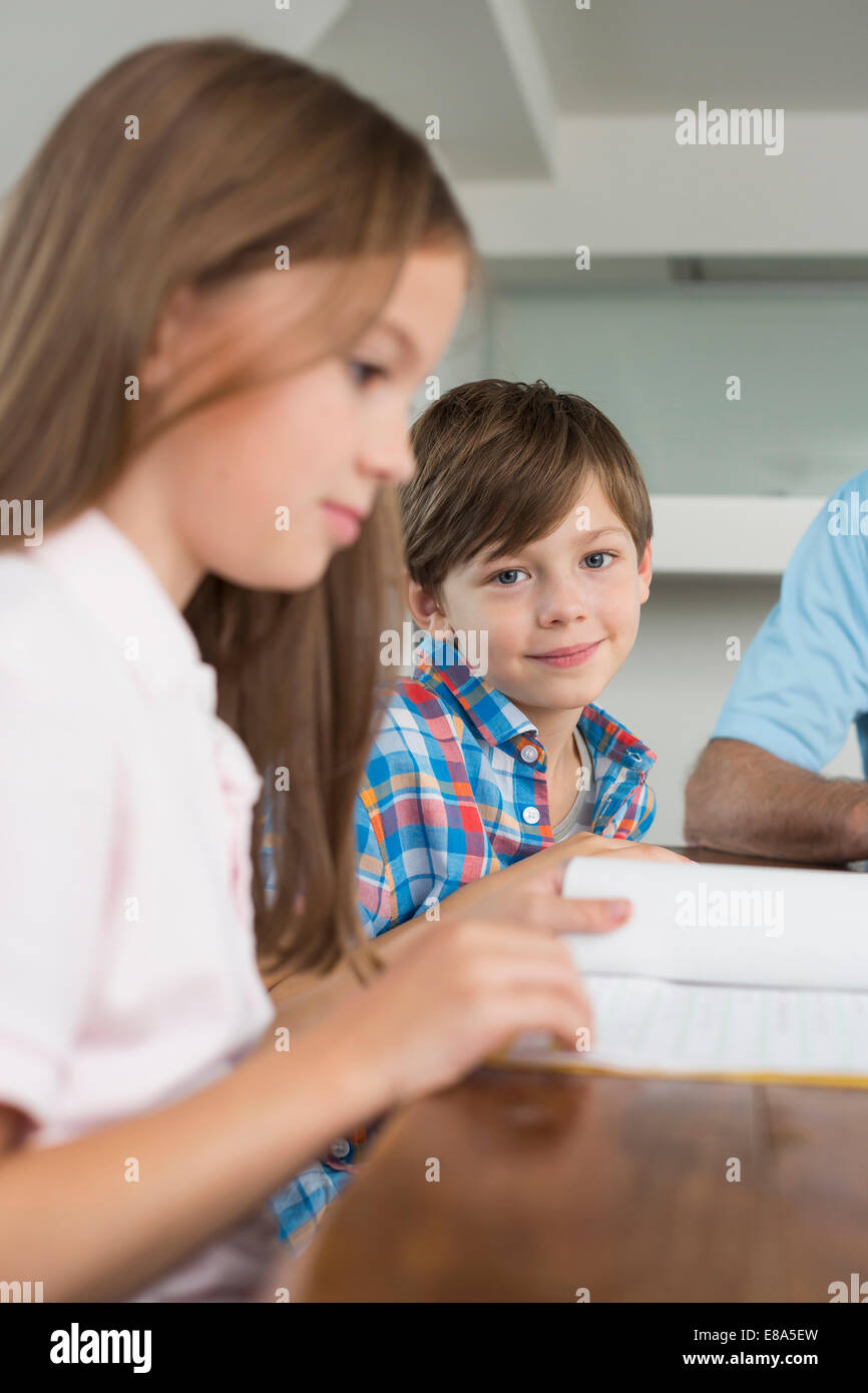 Children doing homework with their grandfather Stock Photo - Alamy