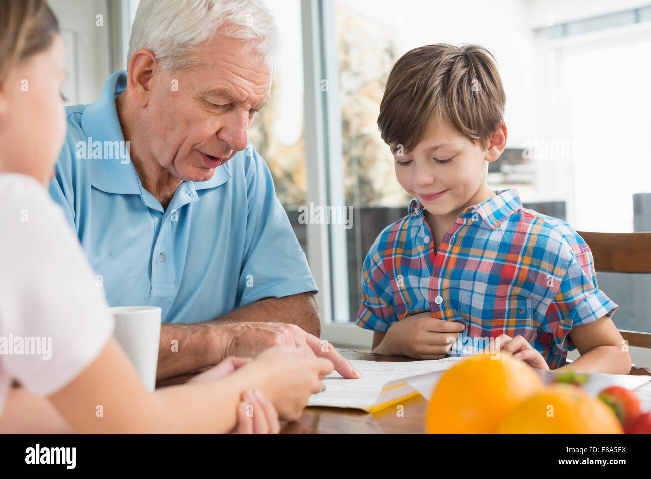 Children doing homework with their grandfather Stock Photo - Alamy