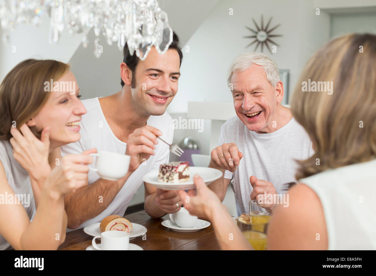 Family with adult children at table eating cake Stock Photo - Alamy