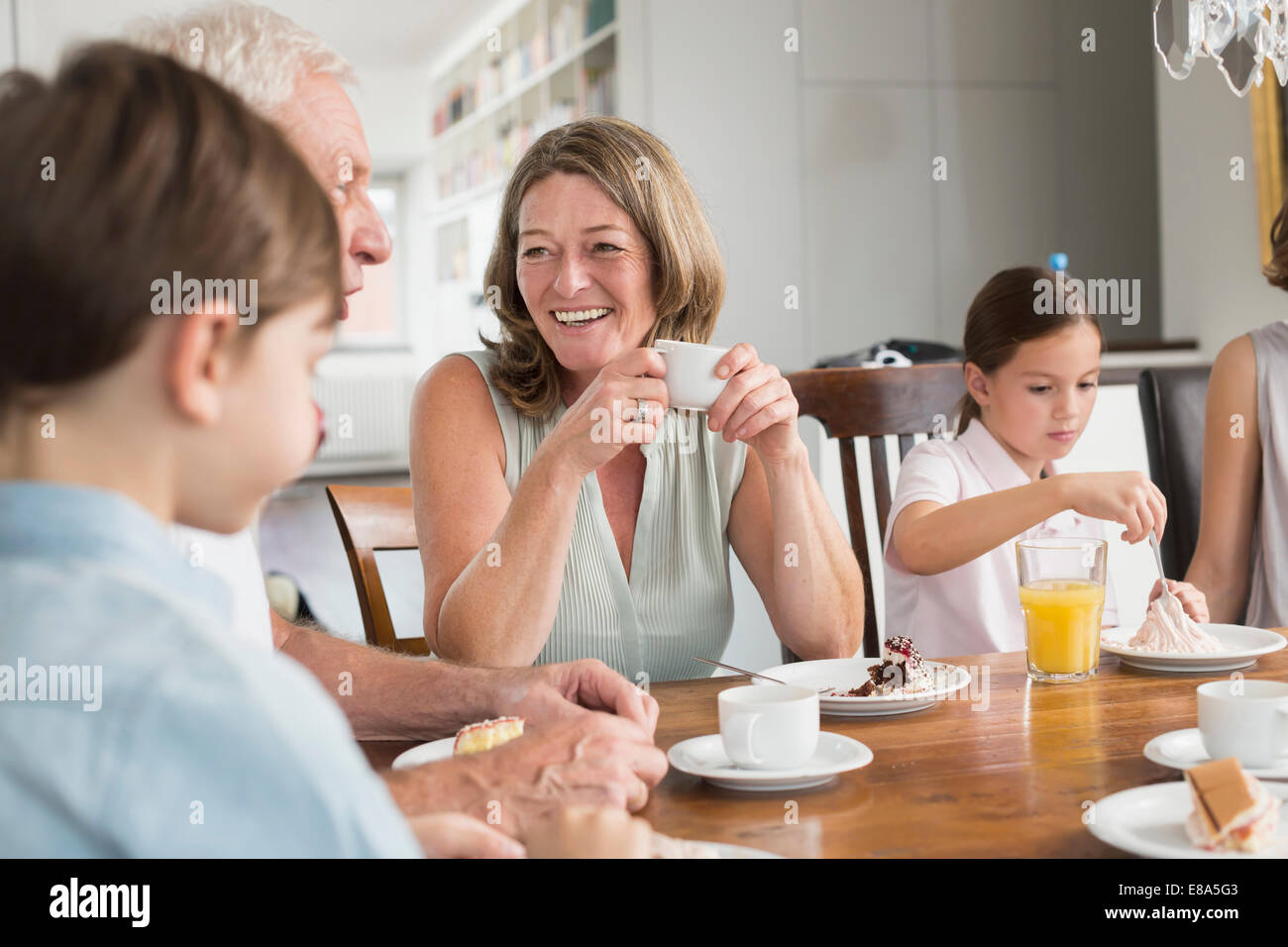 Extended family at table eating cake Stock Photo - Alamy