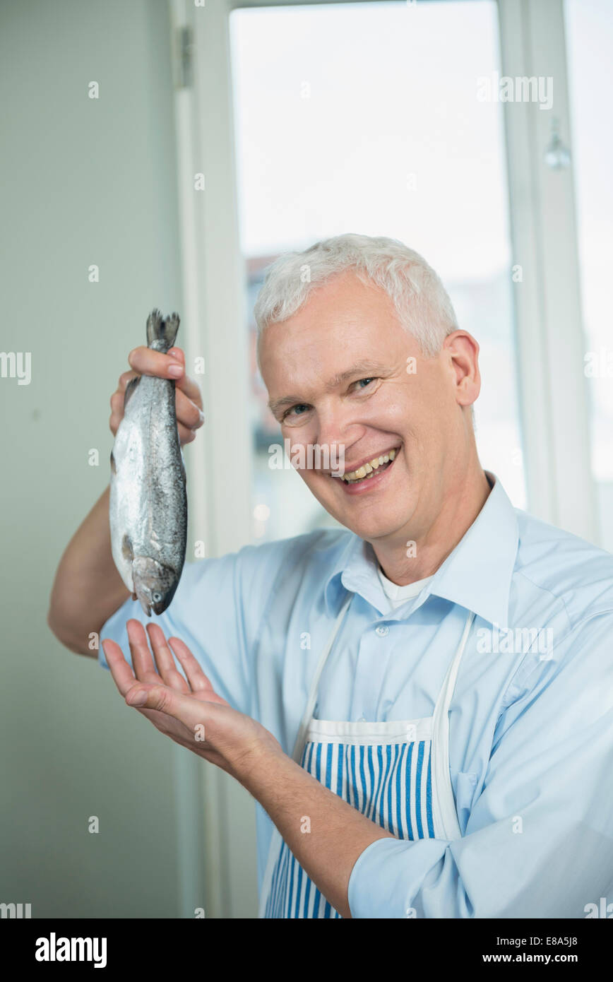 Portrait of mature man holding trout, smiling Stock Photo - Alamy
