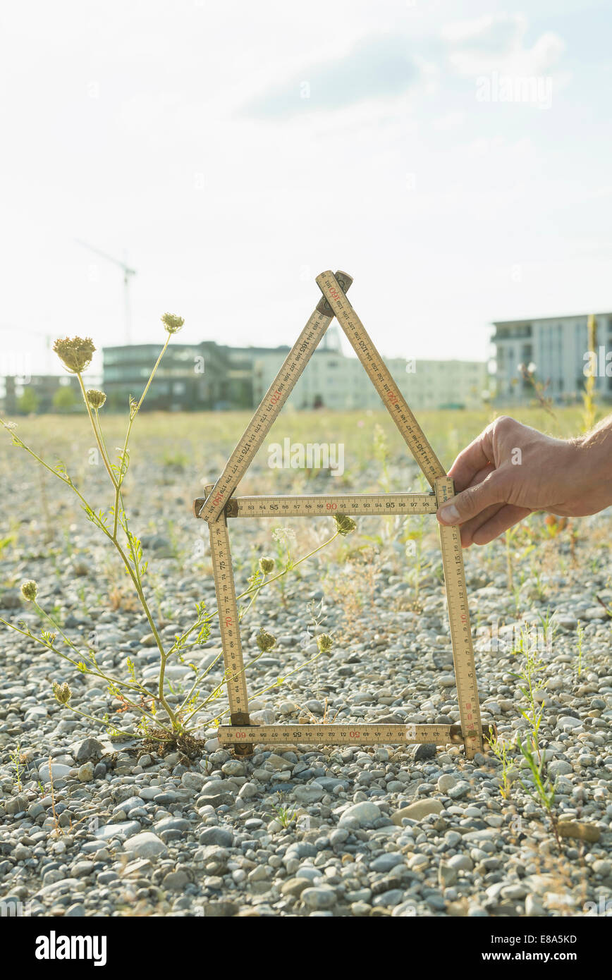 Hand holding model house at development area Stock Photo - Alamy