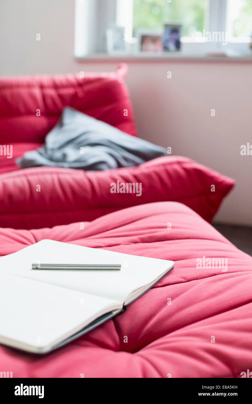 Notebook with pen on couch Stock Photo - Alamy