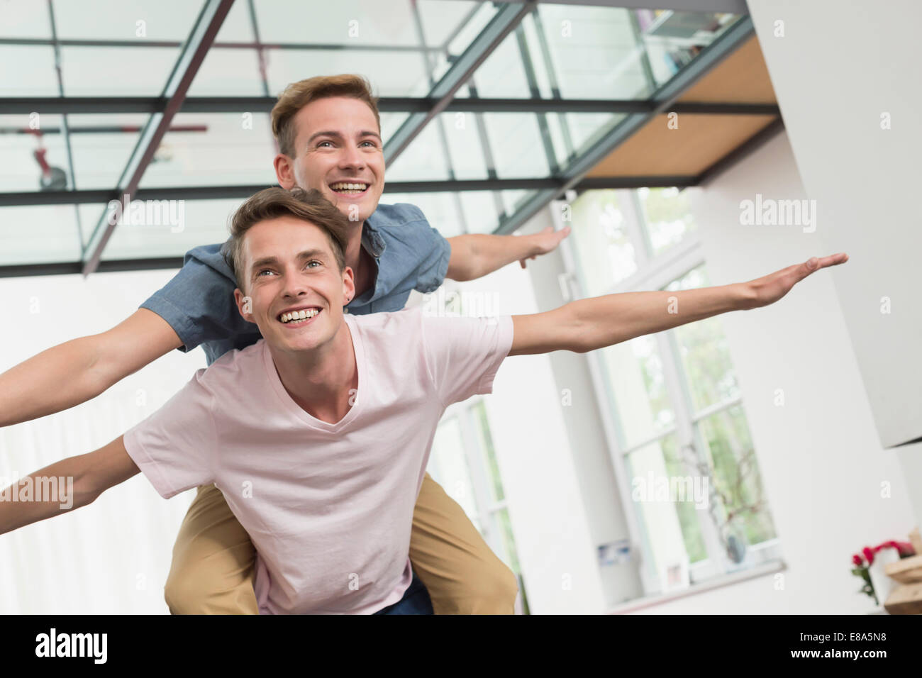 Homosexual couple giving piggyback ride, smiling Stock Photo - Alamy