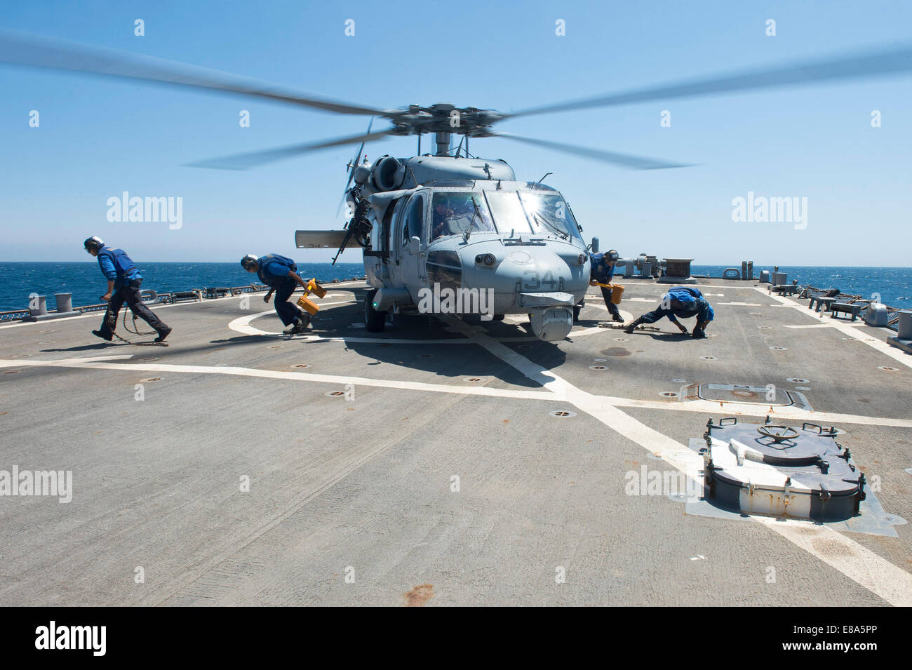 U.S. Sailors remove chocks and chains from an MH-60S Seahawk helicopter ...