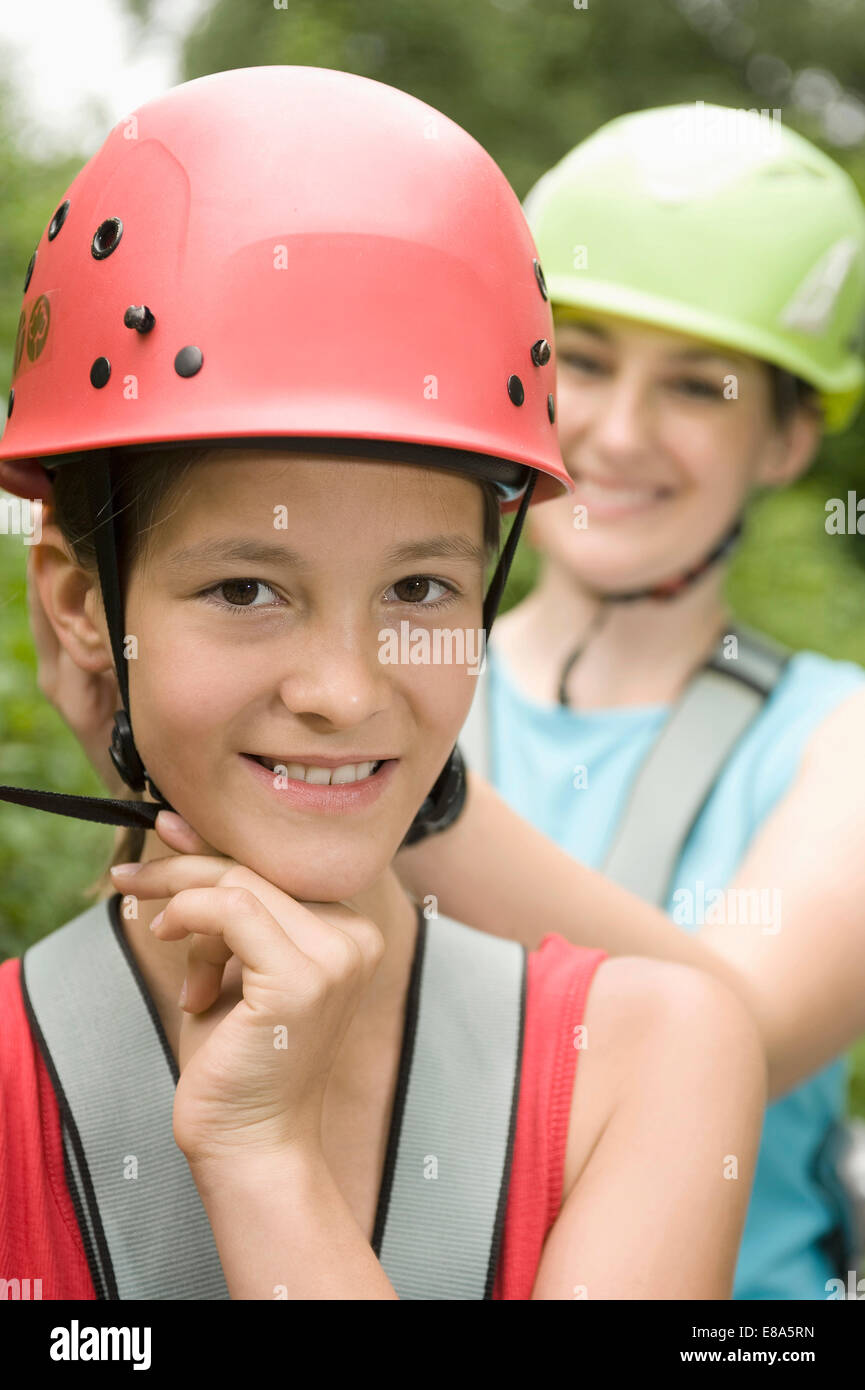 Young woman adjusting helmet of girl, smiling Stock Photo - Alamy