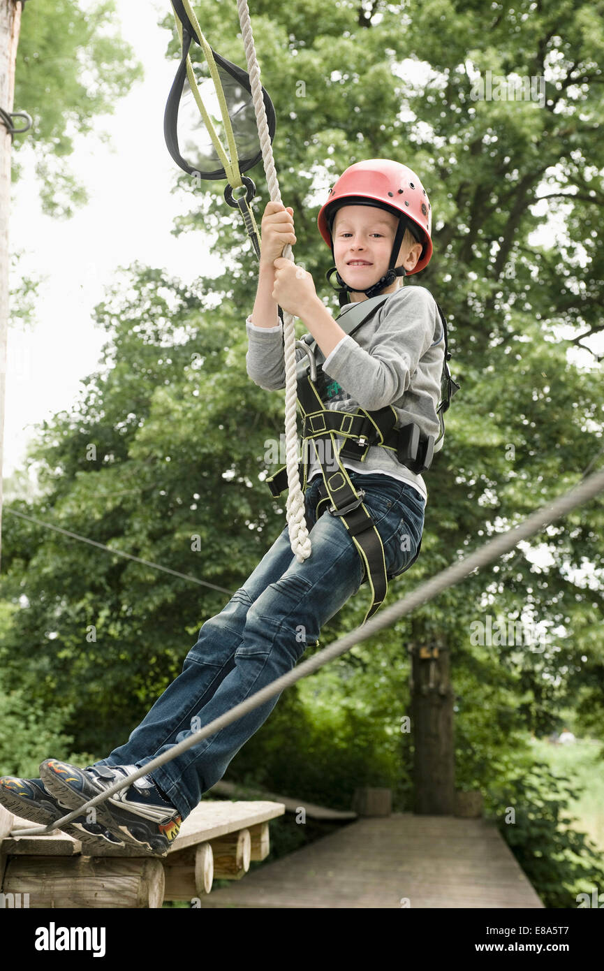 Boy climbing crag, smiling Stock Photo - Alamy