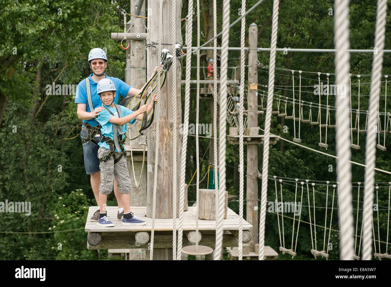 Mature man and boy climbing crag, smiling Stock Photo - Alamy