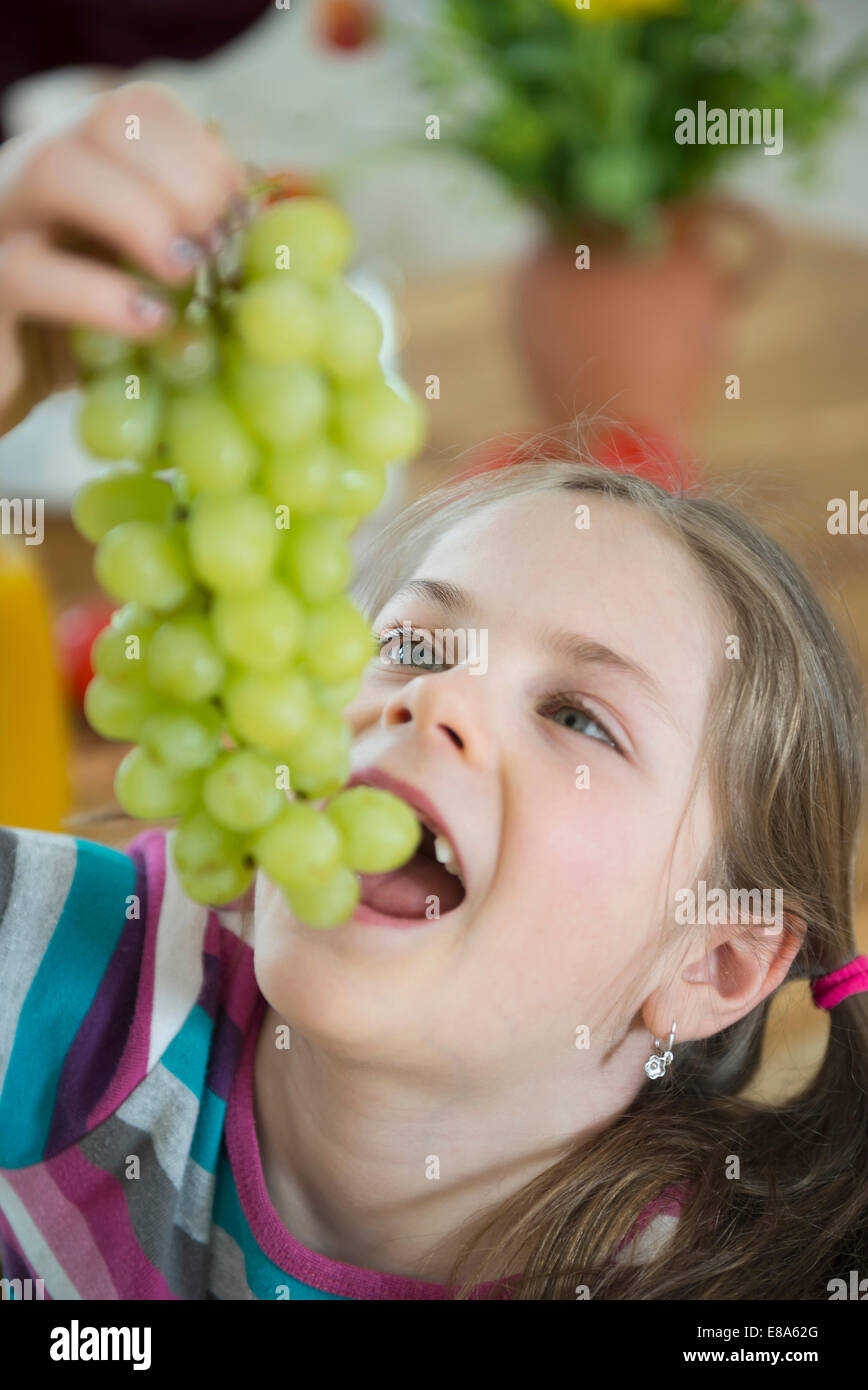 Girl eating bunch of grapes, close up Stock Photo - Alamy