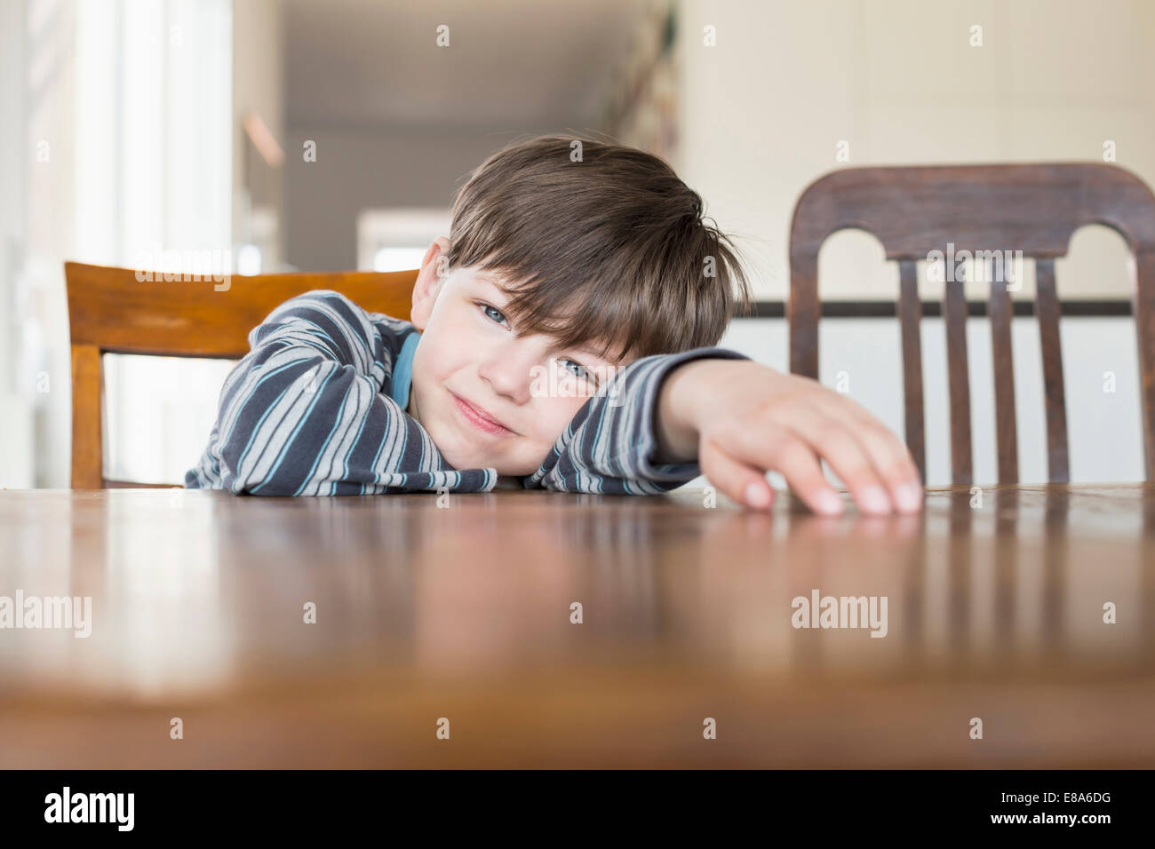 Portrait of boy leaning on wooden table, smiling Stock Photo - Alamy