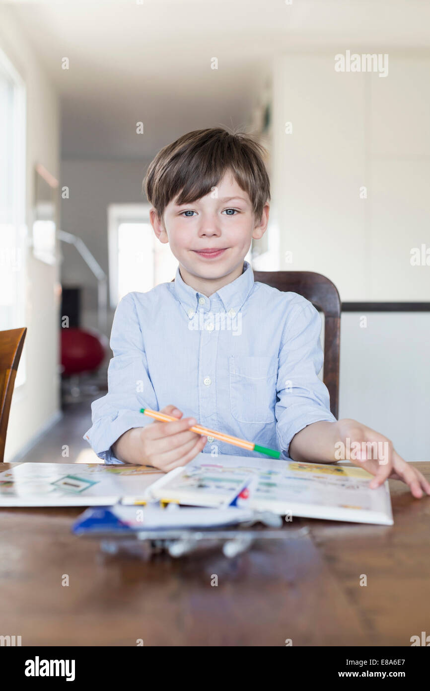 Portrait of boy doing his homework, smiling Stock Photo - Alamy