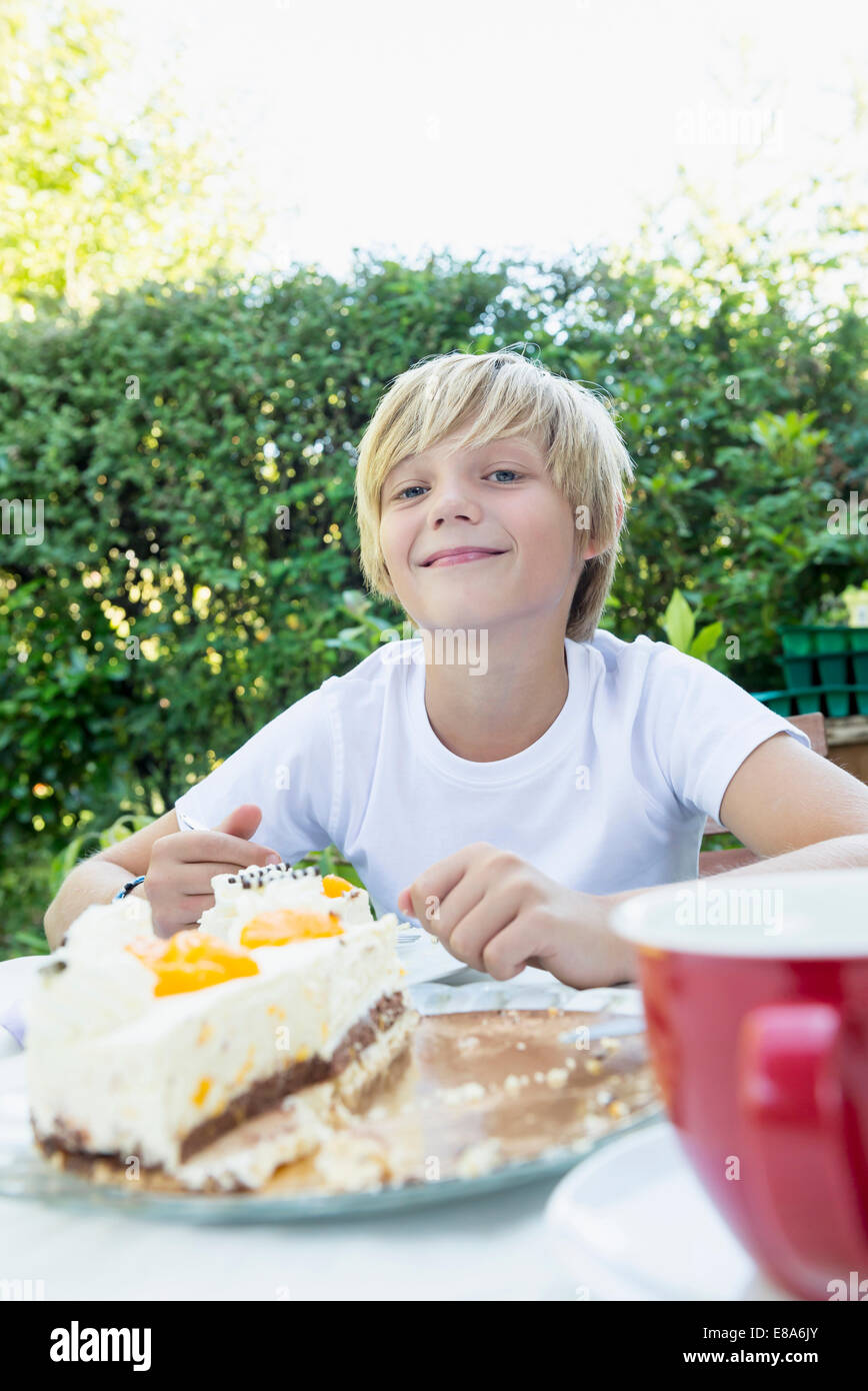 Smiling young boy with cream cake Stock Photo - Alamy