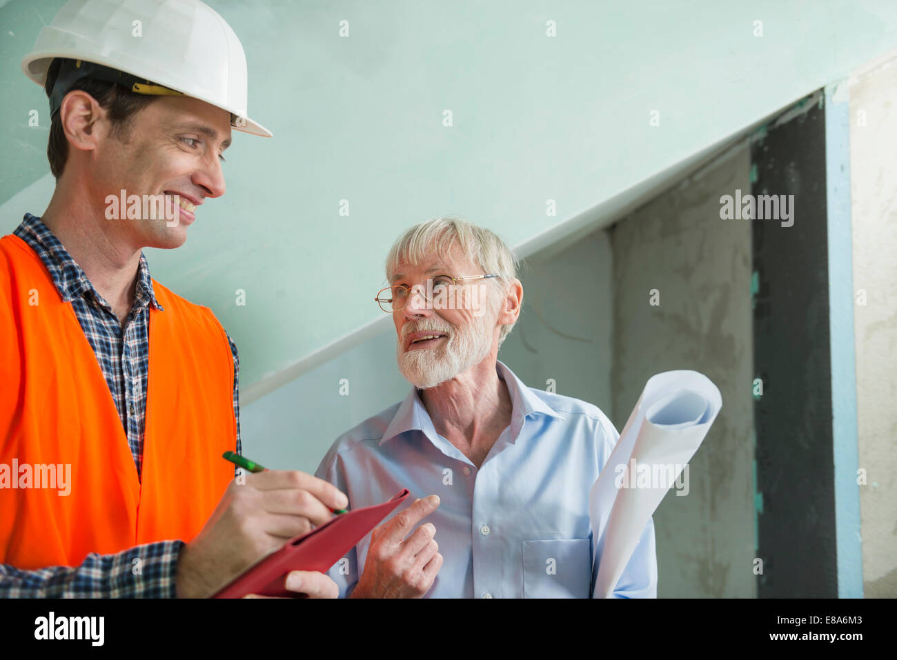Architect and construction worker at construction site of new building ...