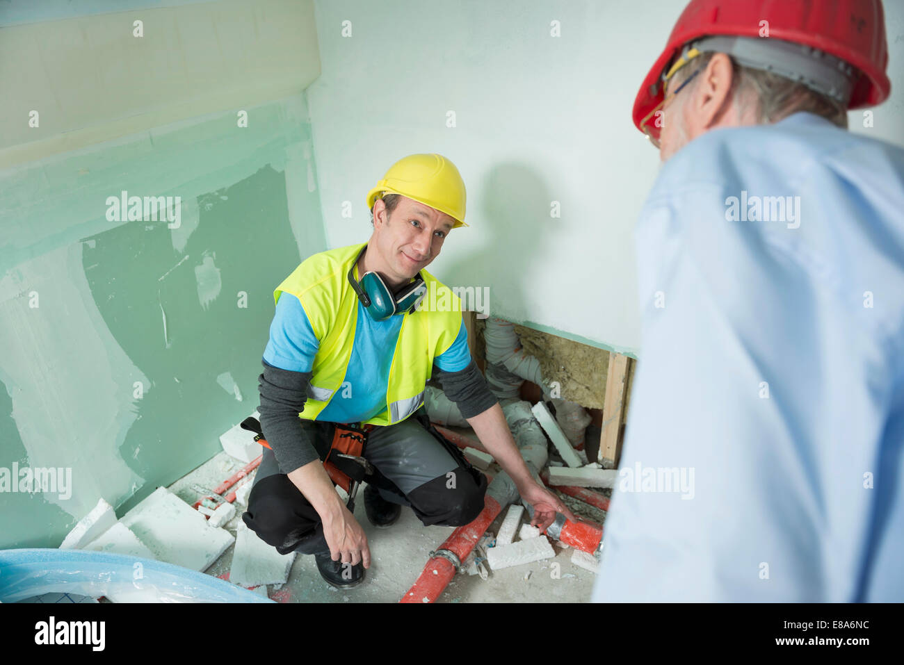 Manual worker working crouching construction site safety helmet hi-res ...