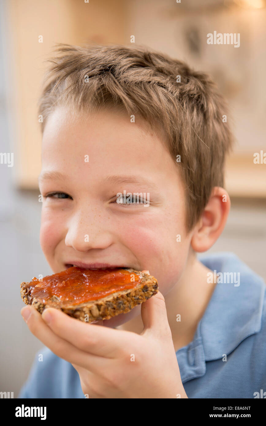 Portrait of smiling boy eating bread with jam Stock Photo - Alamy