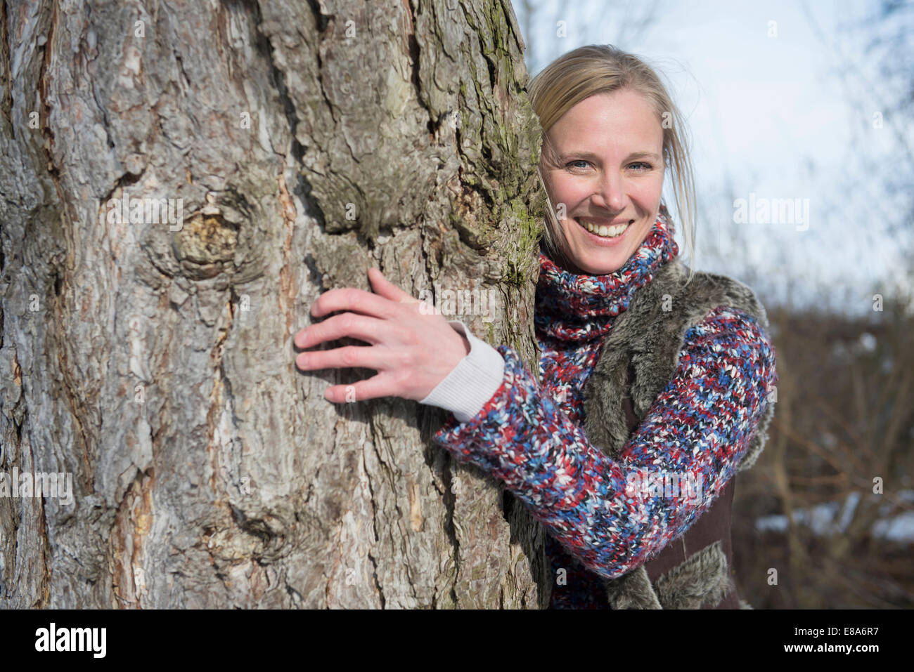 Portrait of woman hugging tree trunk, smiling, Bavaria, Germany Stock ...