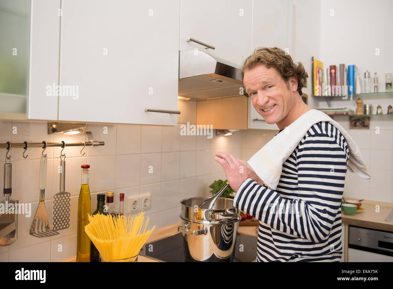 Man in kitchen cooking spaghetti Stock Photo - Alamy
