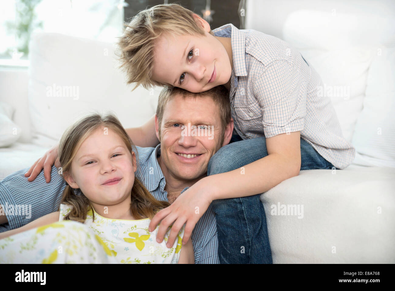 Father sitting on couch with children Stock Photo - Alamy