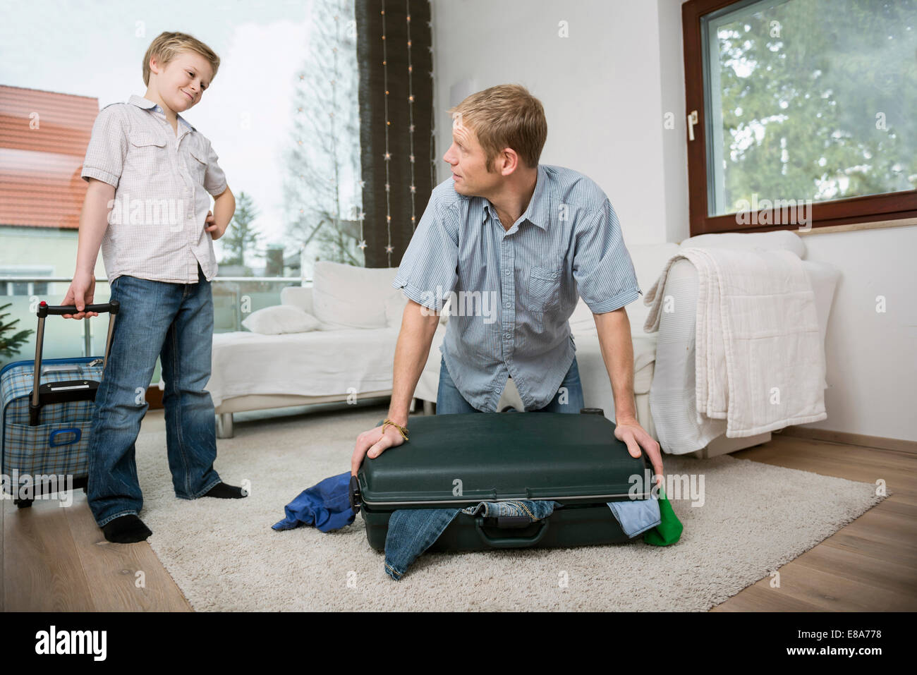 Father and son packing suitcase Stock Photo - Alamy