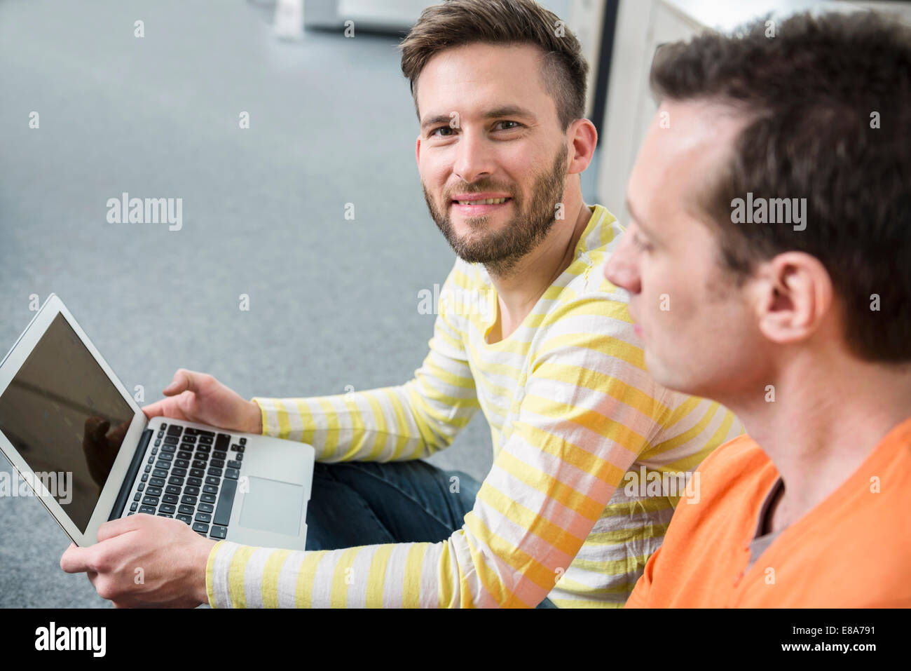 Two young men office portrait planning laptop Stock Photo - Alamy